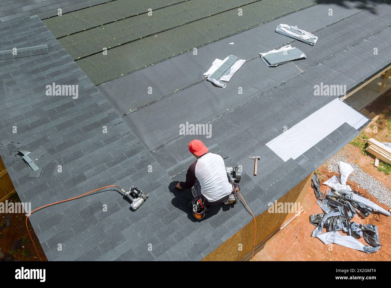 With assistance an air nail gun, professional roofing contractor ...