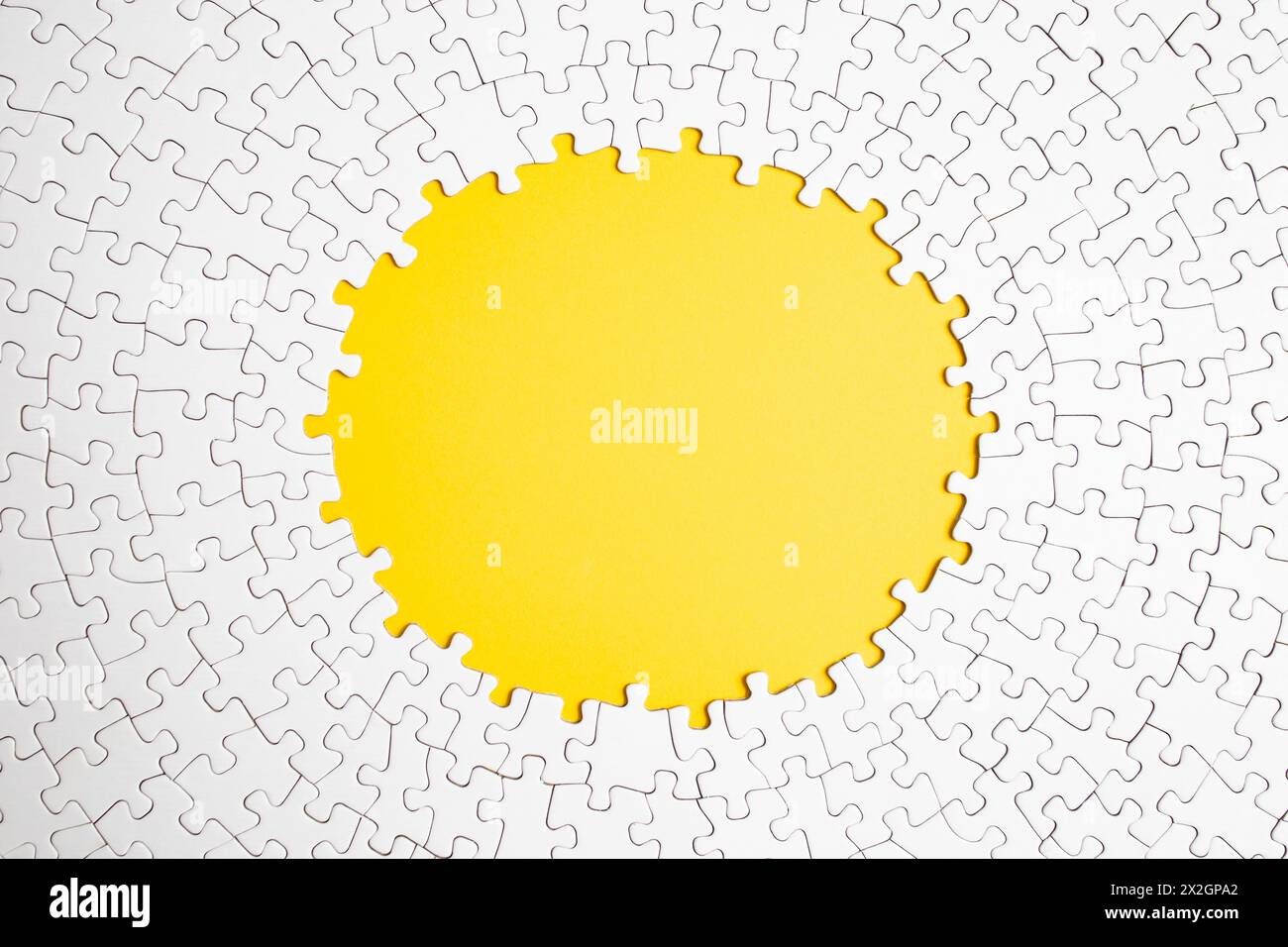 Plain white jigsaw puzzle on yellow color background, oval shaped frame ...
