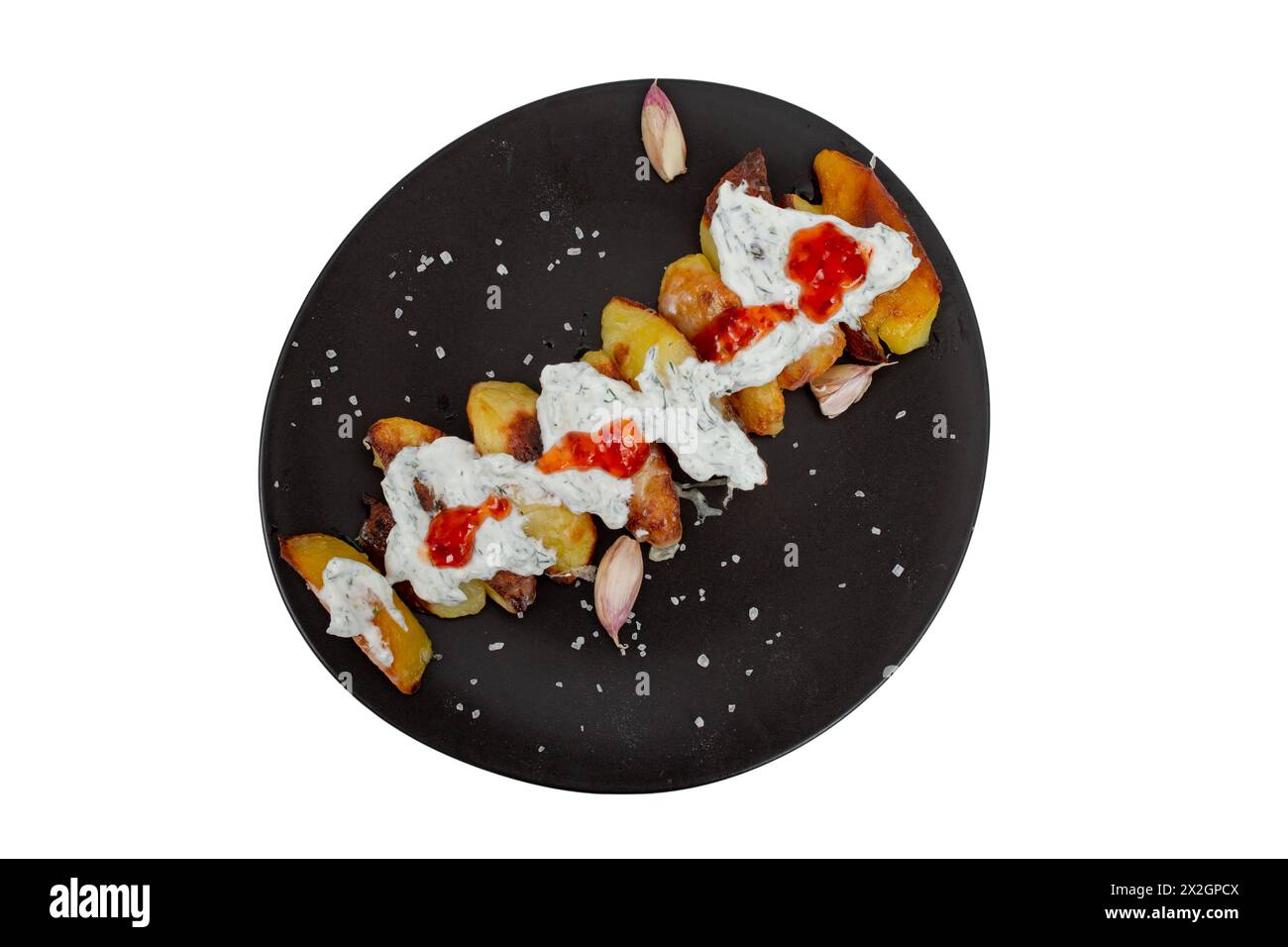 Oven baked potato wedges with tzatziki sauce and red chili paste on a black ceramic plate Stock ...