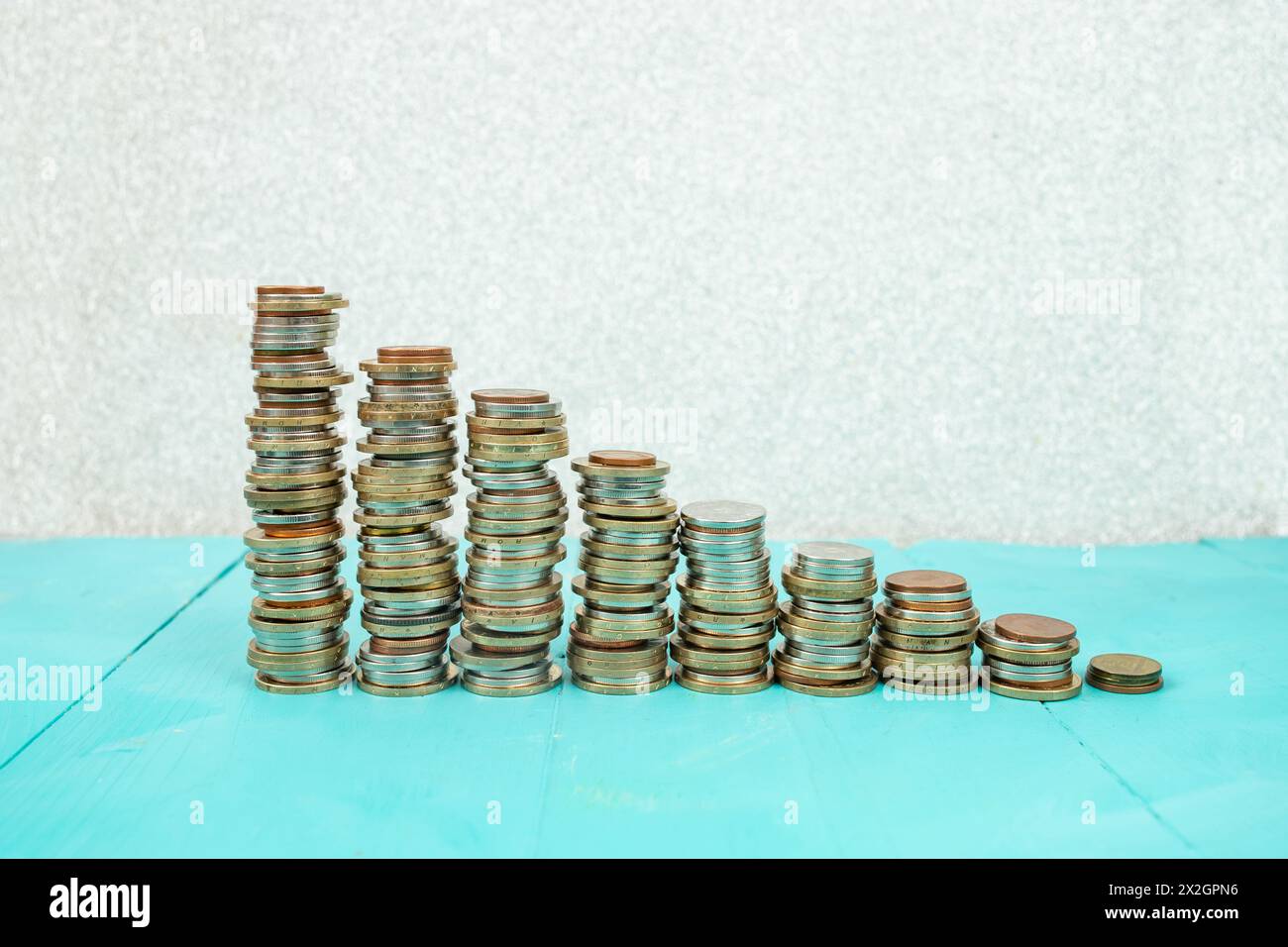 Stack of coins bar chart graph trending downwards with white wall ...
