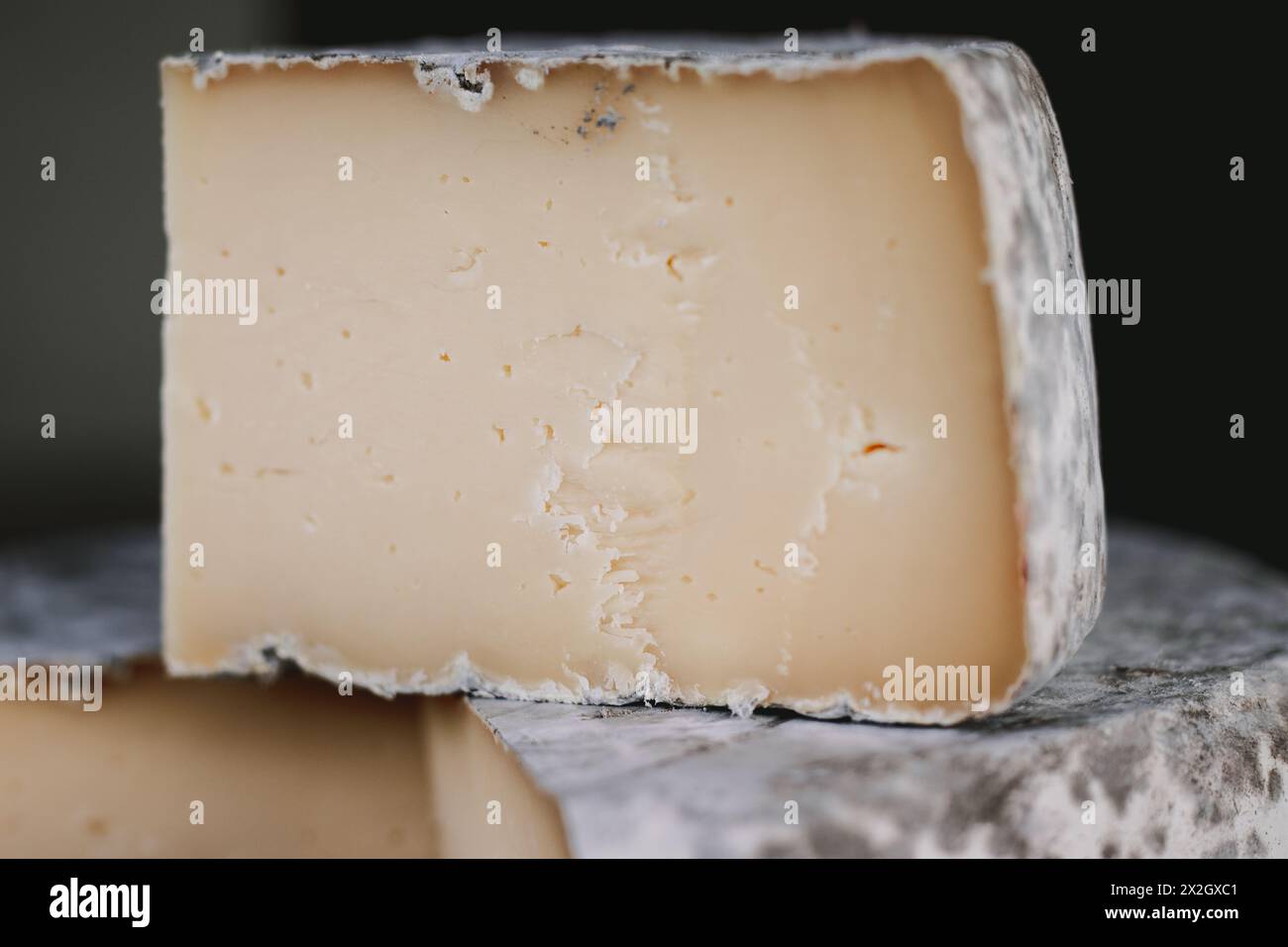 Rustic natural rind cheese wedge Stock Photo - Alamy