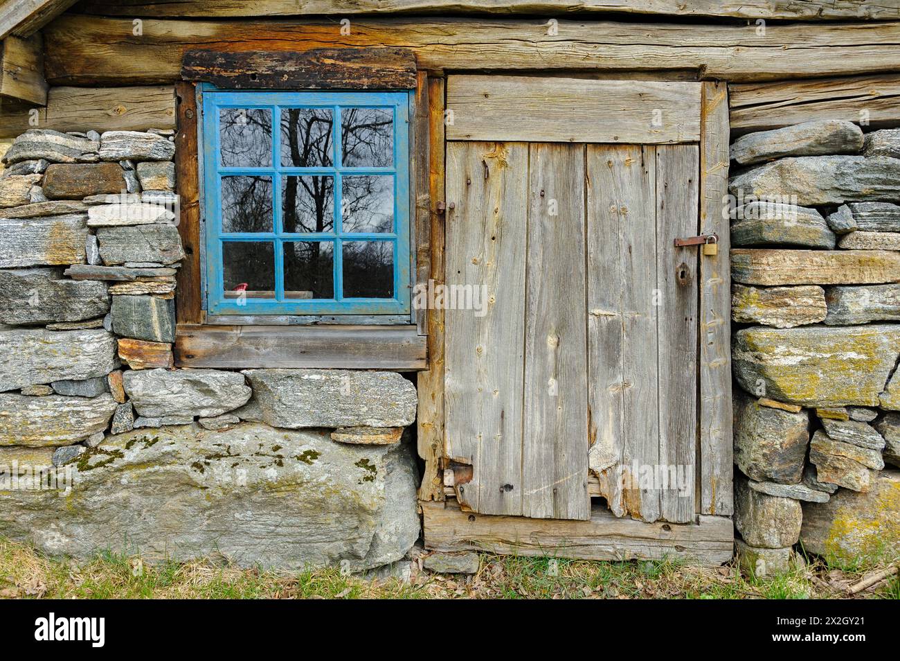 A close-up view of an old wooden cabins stone foundation, weathered ...