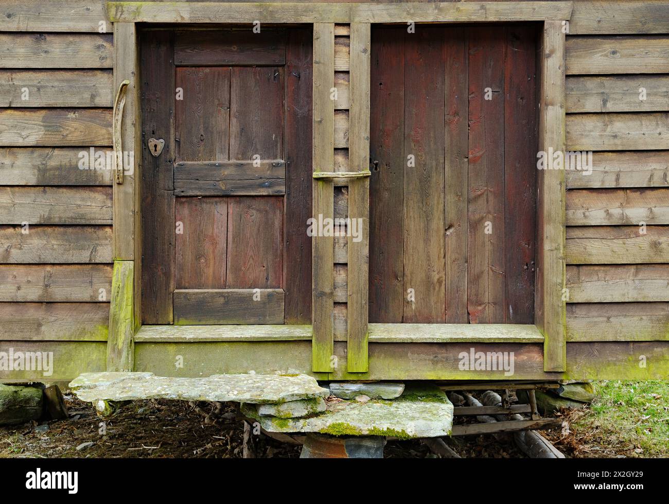 Weathered wooden doors of an old barn provide a glimpse into pastoral ...