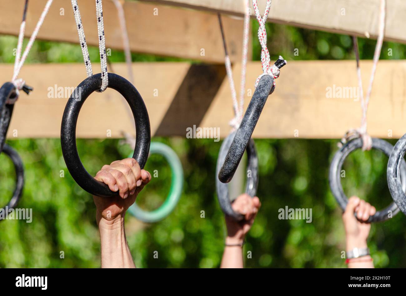 selective focus, athletes hands at a hanging obstacle with metal rings ...