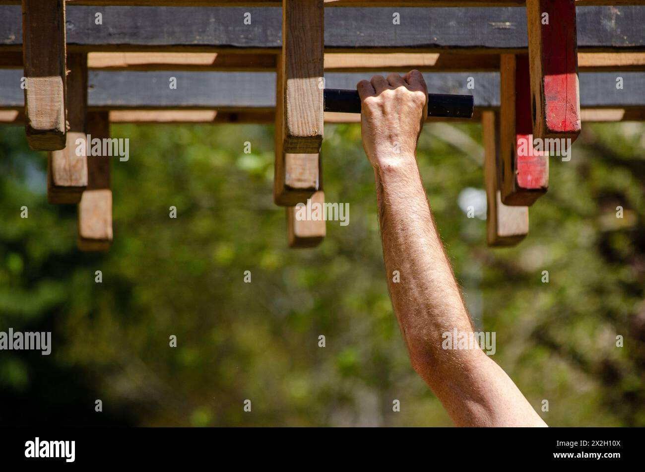 athlete hand at a hanging obstacle at an obstacle course race, OCR ...