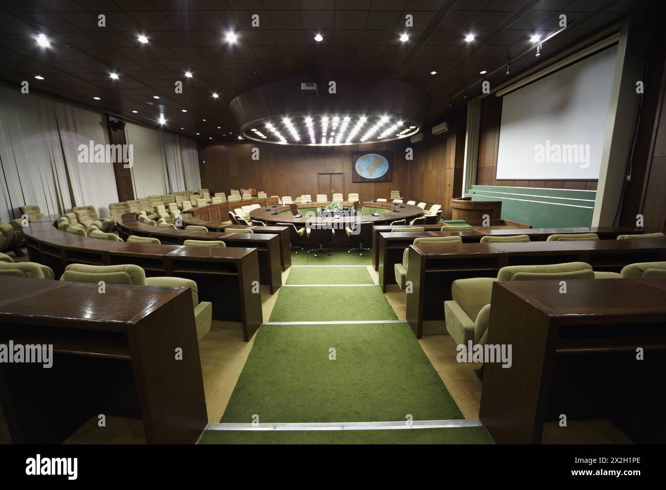 Auditorium with round oak table and beige armchairs around it Stock ...