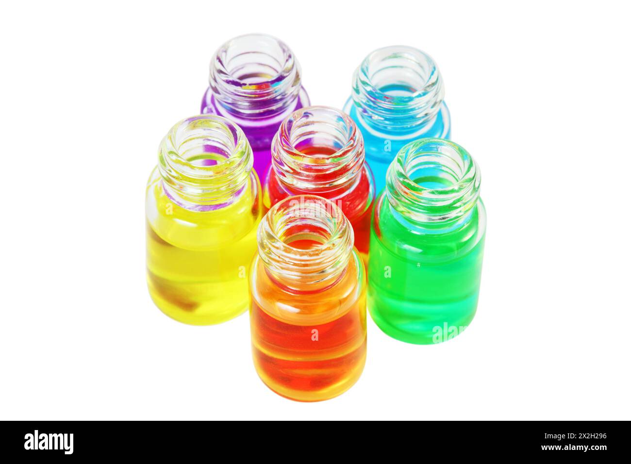 Six small bottles of different colored aromatic oils isolated on white ...