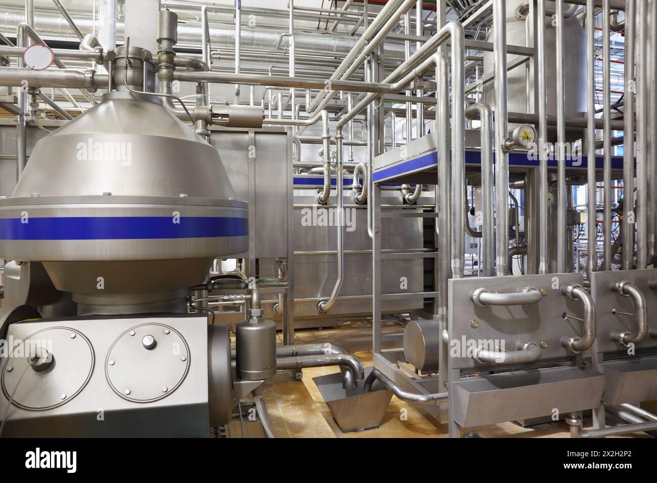 Lots of different interlocking metal pipes in lit room at large factory ...