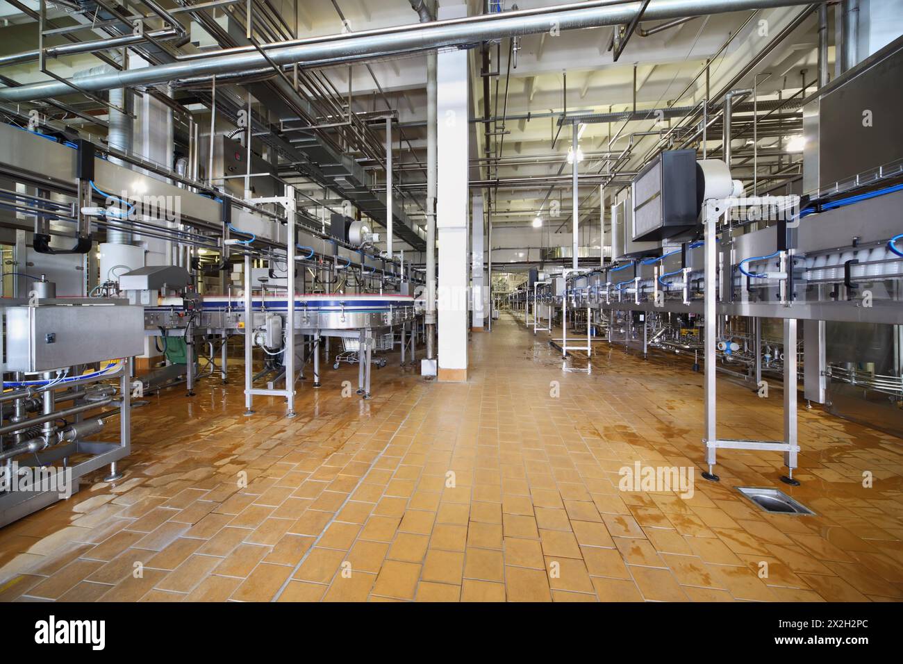 Lots of different metal pipes and conveyers with milk bottles in milk ...