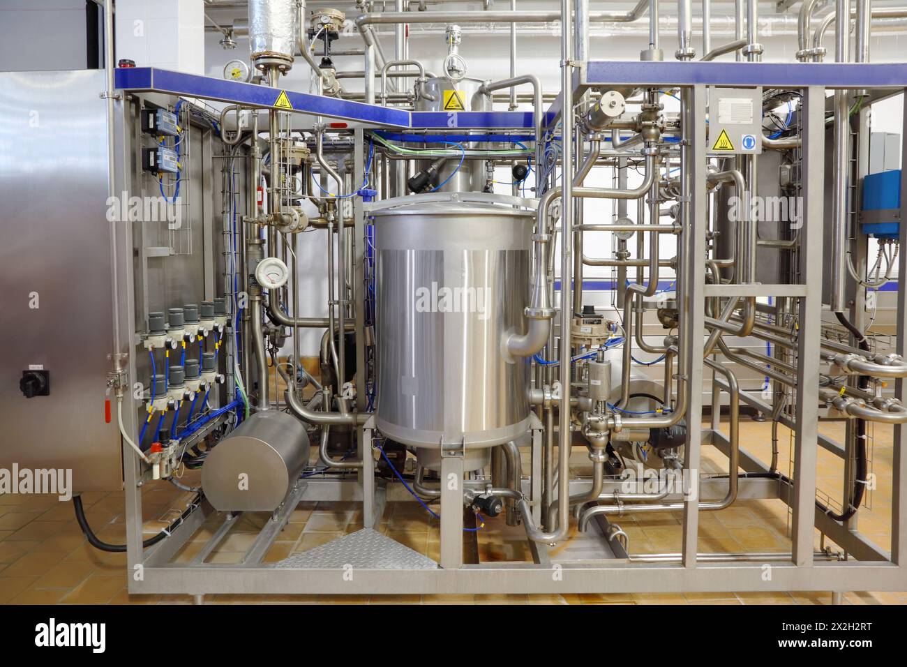 Lots of different interlocking metal pipes and reservoirs in lit room ...