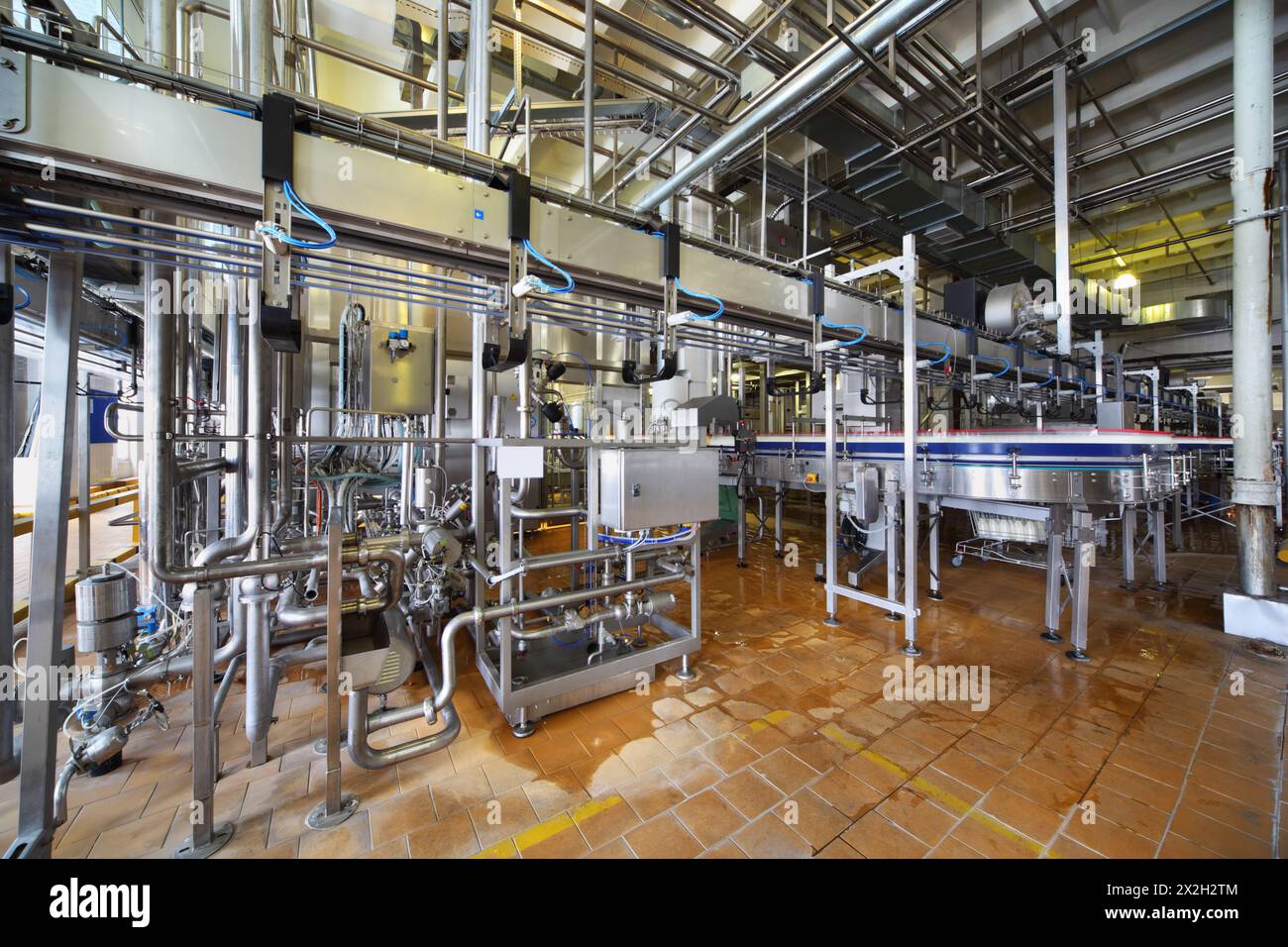 milk bottles quickly move through long pipeline in large factory ...