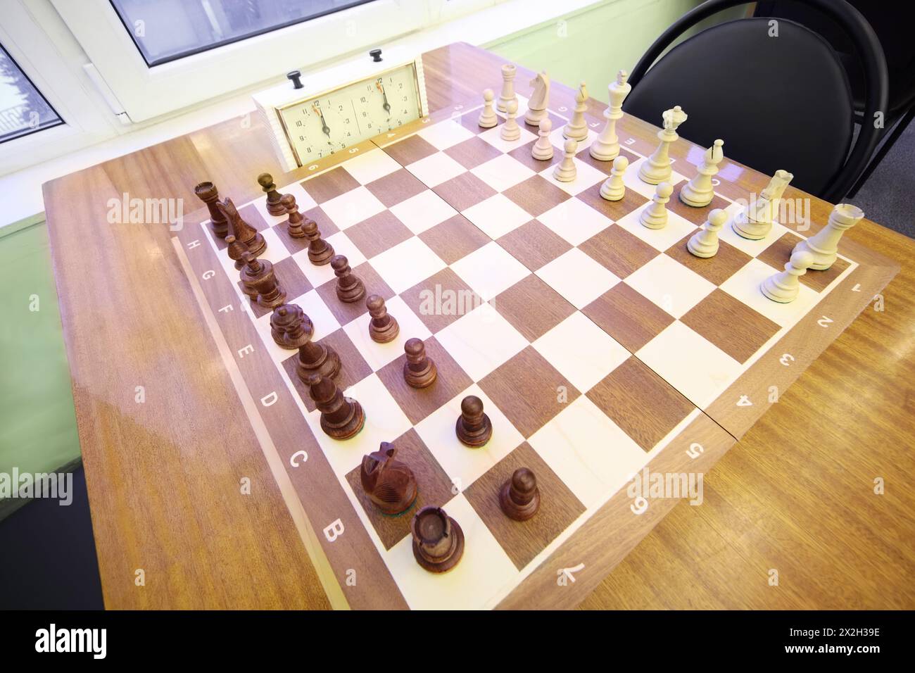 Chess stand on chessboard in room of chess club; brown and white wooden ...