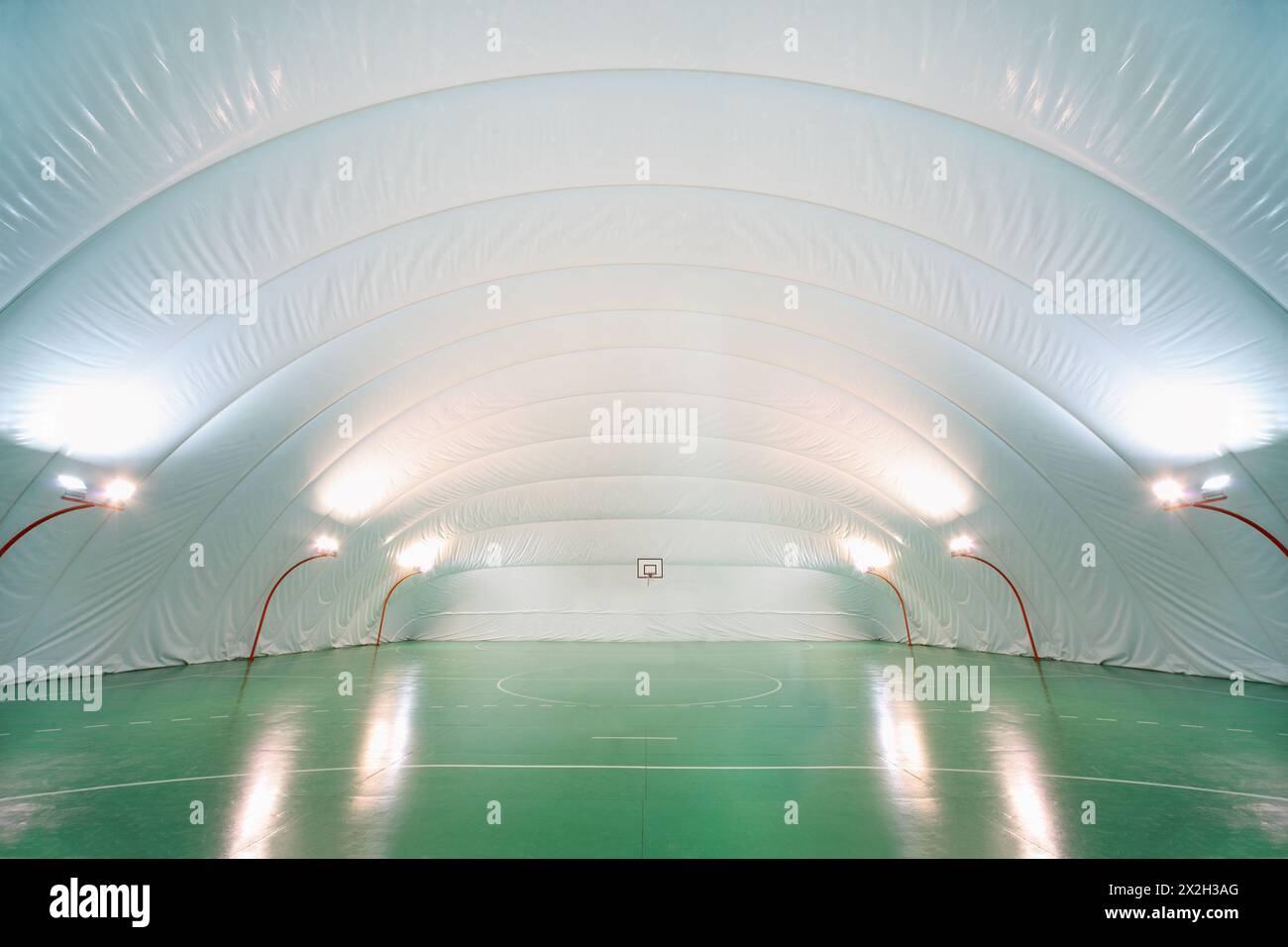 People train in indoor sports ground, plastic white ceiling and walls ...
