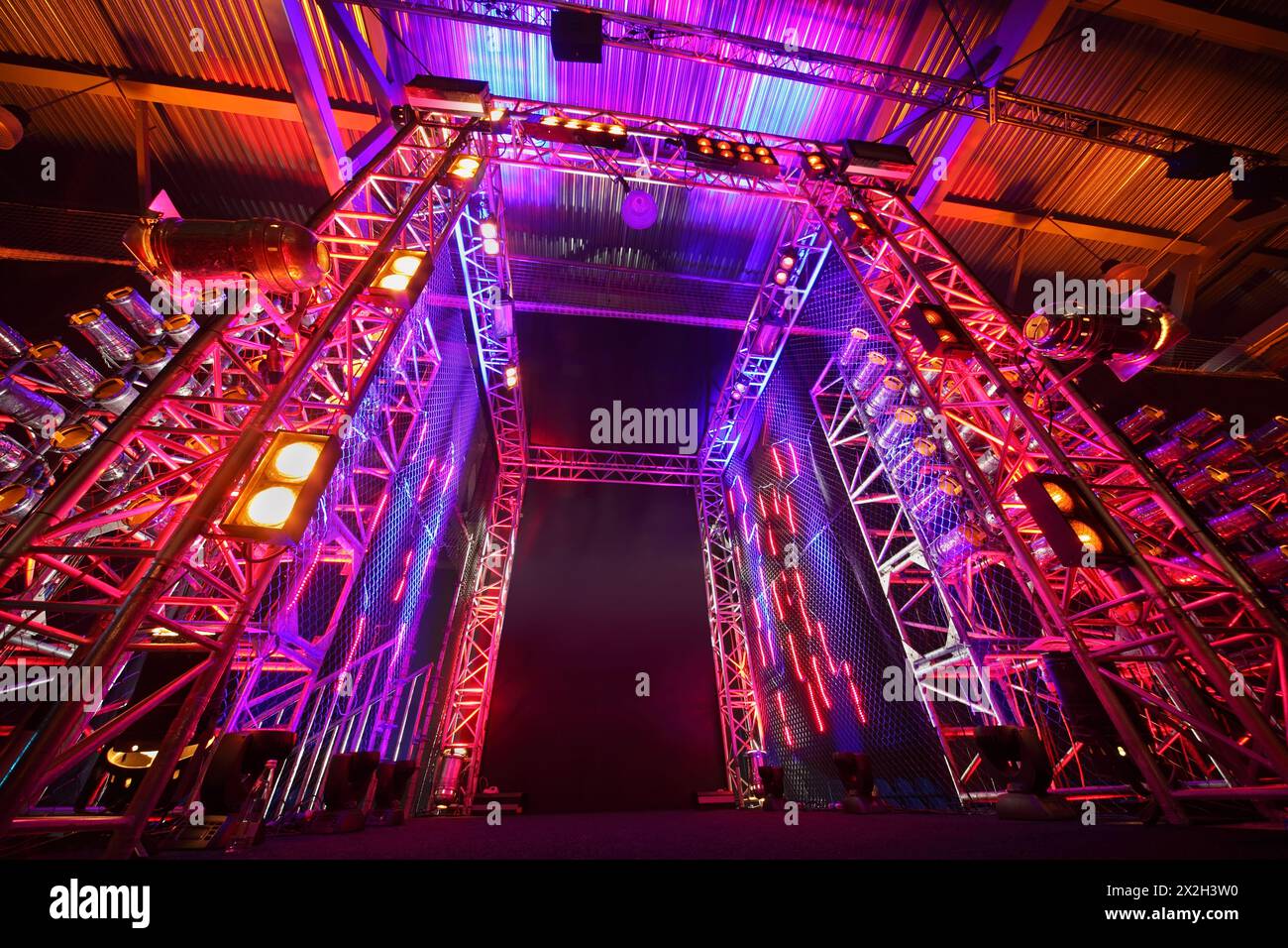 Multi-colored illuminated way to boxing ring inside fight club; many ...