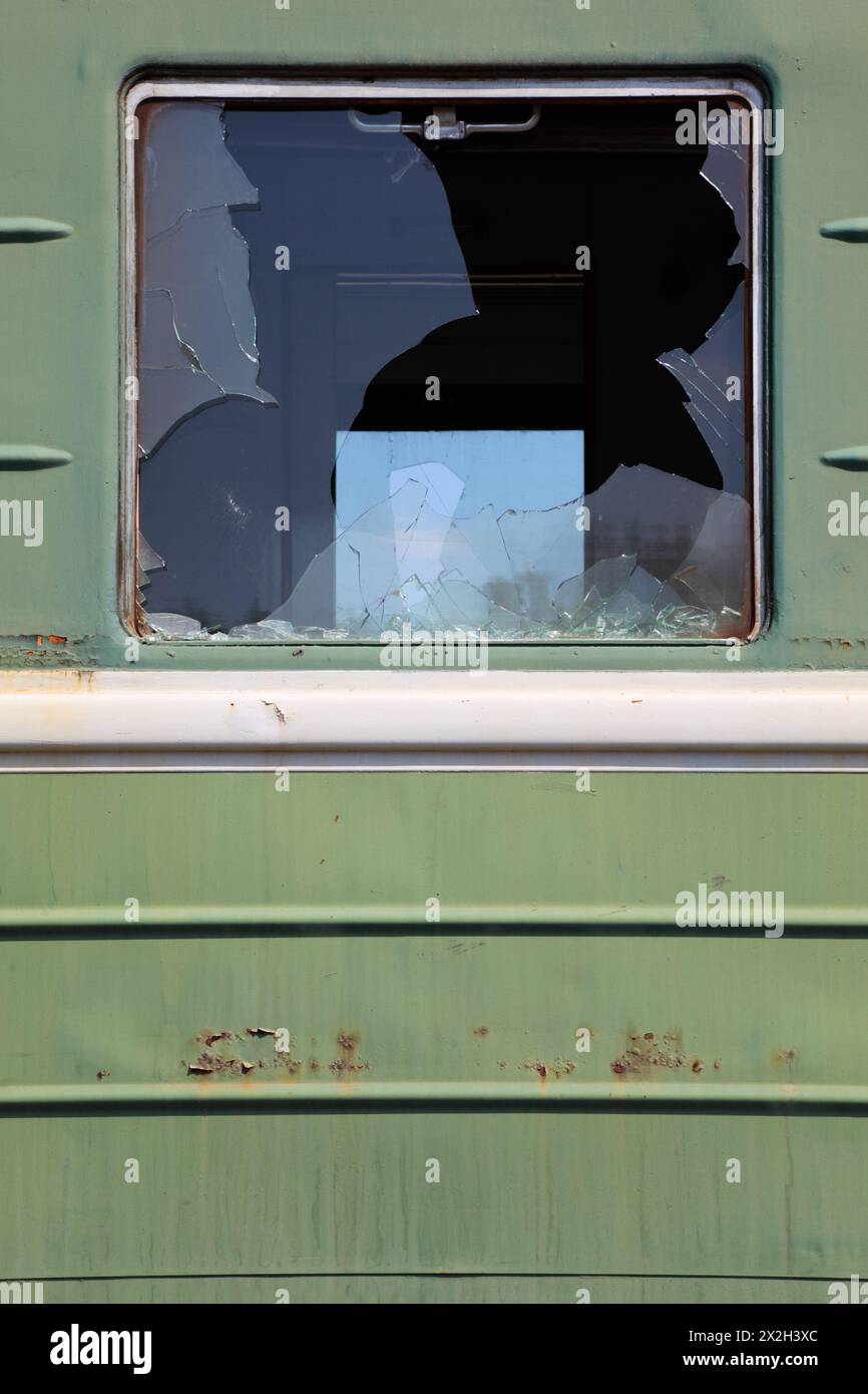 broken window of green old rusty train; vandalism has become part of ...
