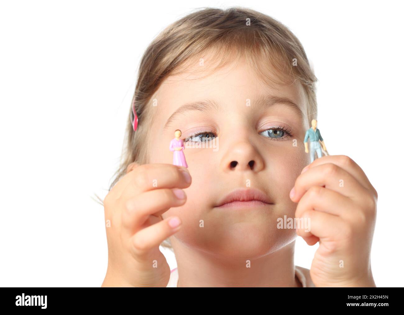 beautiful little girl holding small toy figures of people isolated on ...