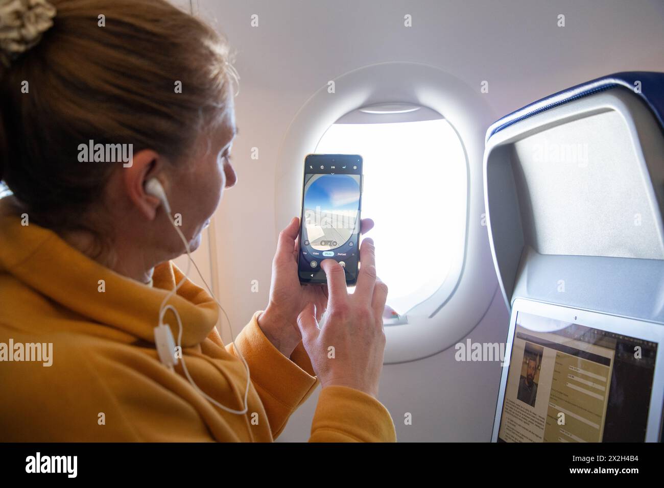 Woman looking through window of plane hi-res stock photography and ...