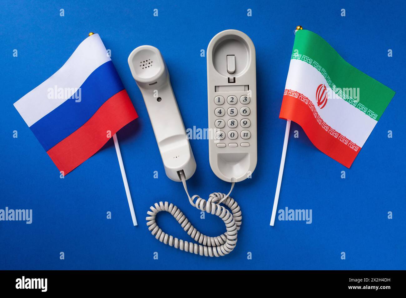 Old telephone and flags of Russia and Iran on a blue background ...