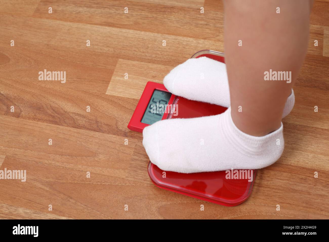 Girl stands on the weights. feet in white socks on the scales Stock ...