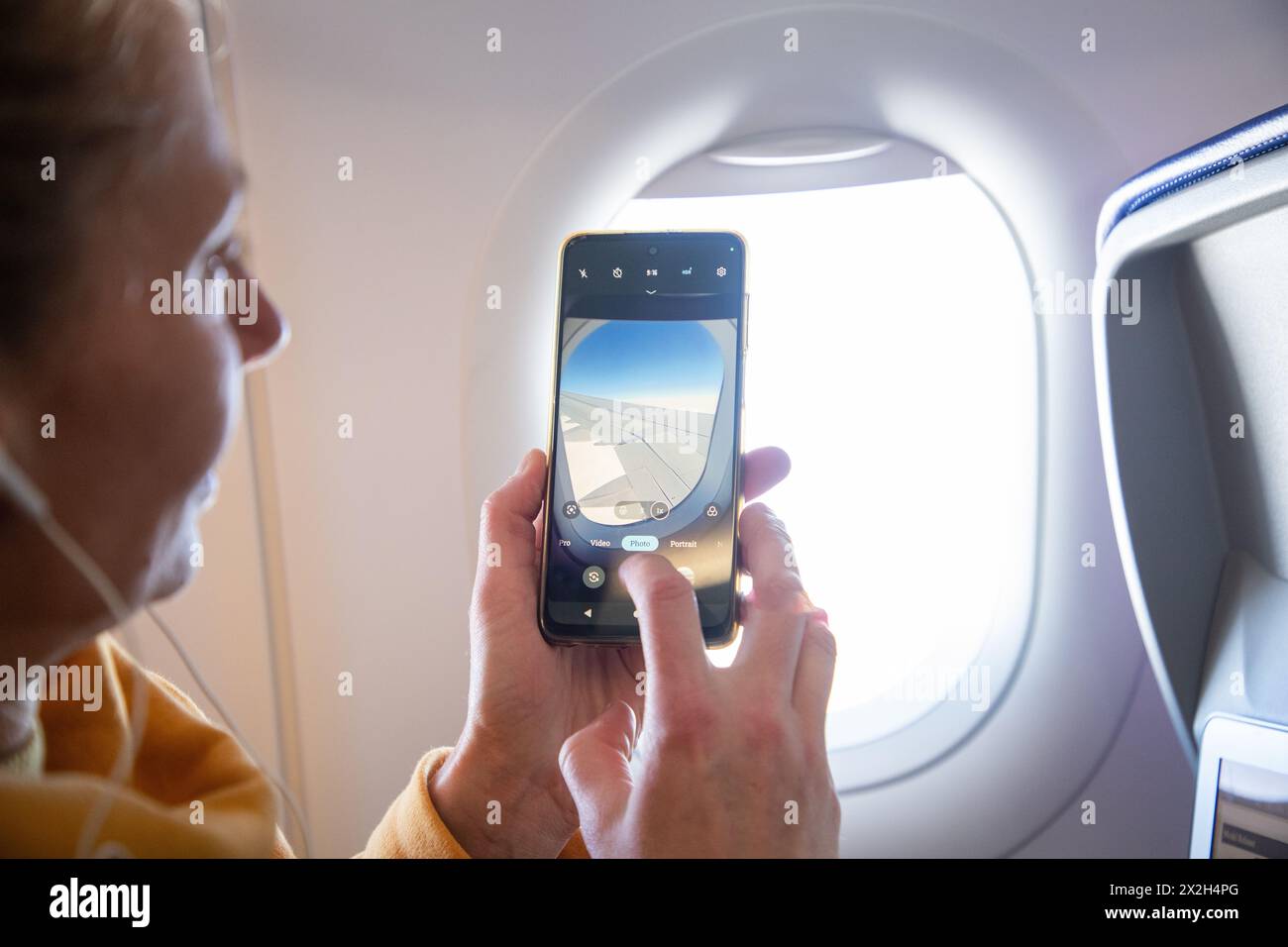 woman taking photos through plane window Stock Photo - Alamy