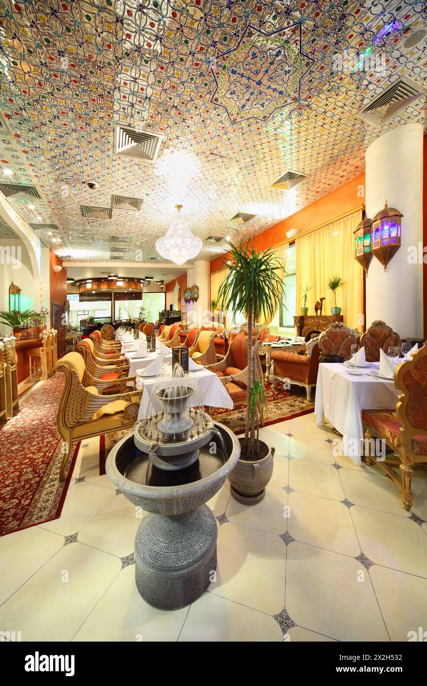 eastern interior of beautiful restaurant, potted palms and fountain ...