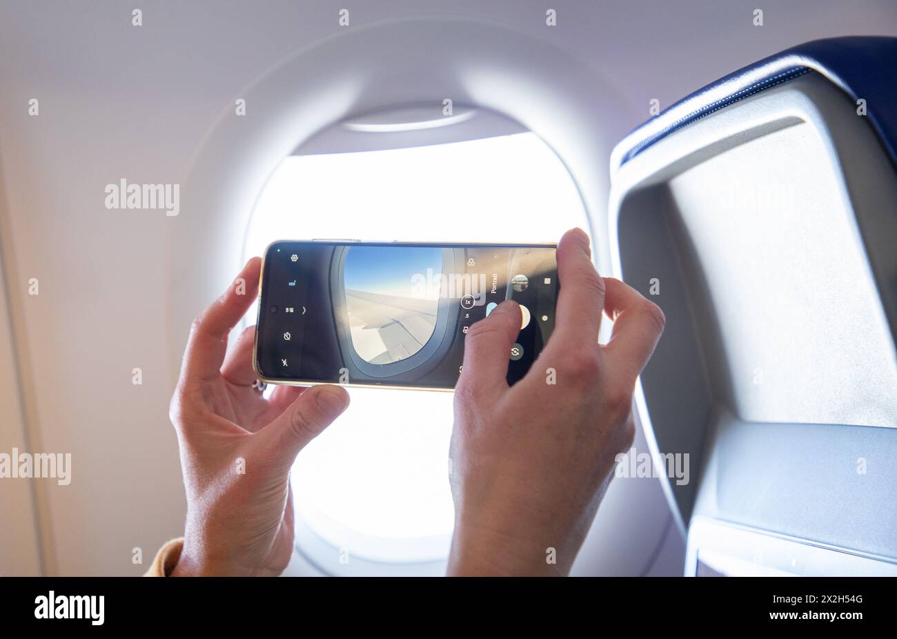 woman taking photos through plane window Stock Photo - Alamy