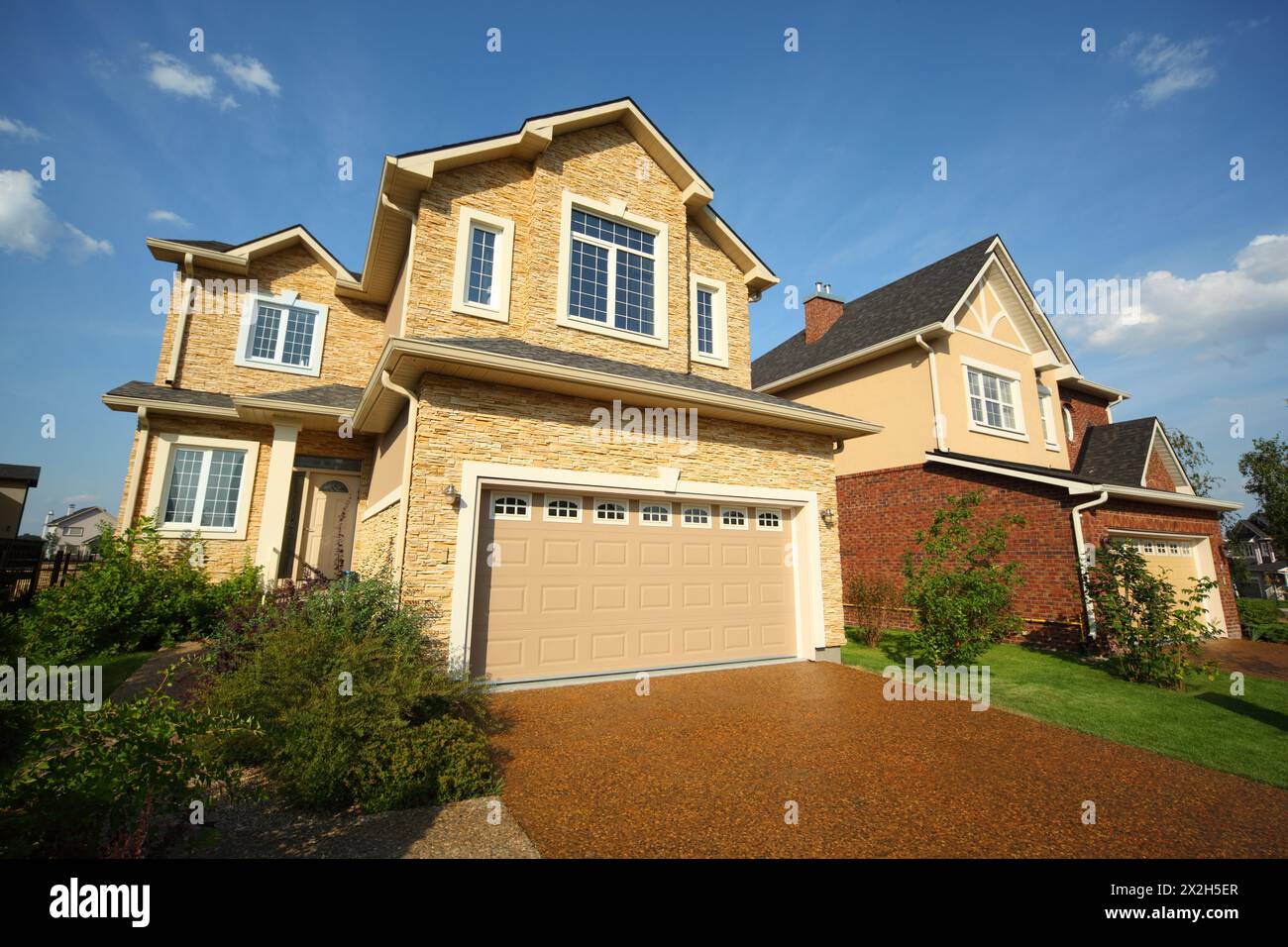 Two new two-storied beige stone and brick cottage with garage and ...