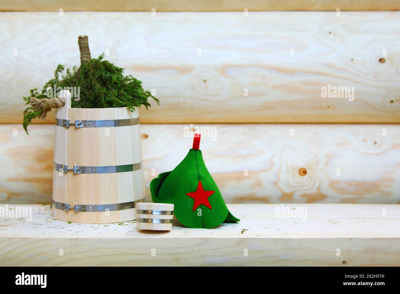 wooden bucket with fir broom and green helmet lie on wooden shelf Stock ...