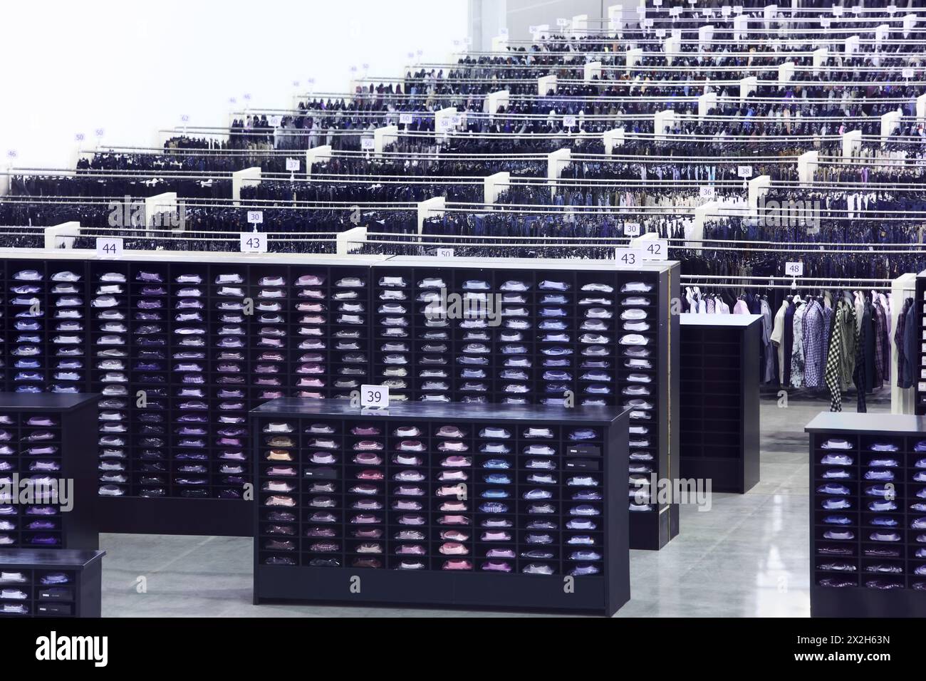 Large clothing store, many rows with hangers, shelves of shirts Stock ...