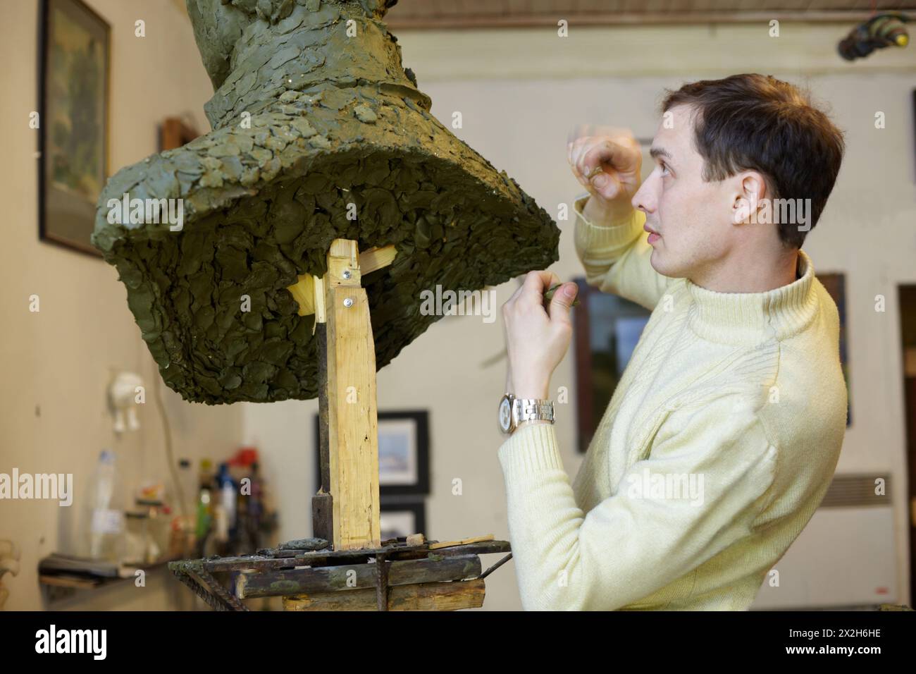 Sculptor works in the studio with a plasticine model of the bust Stock ...