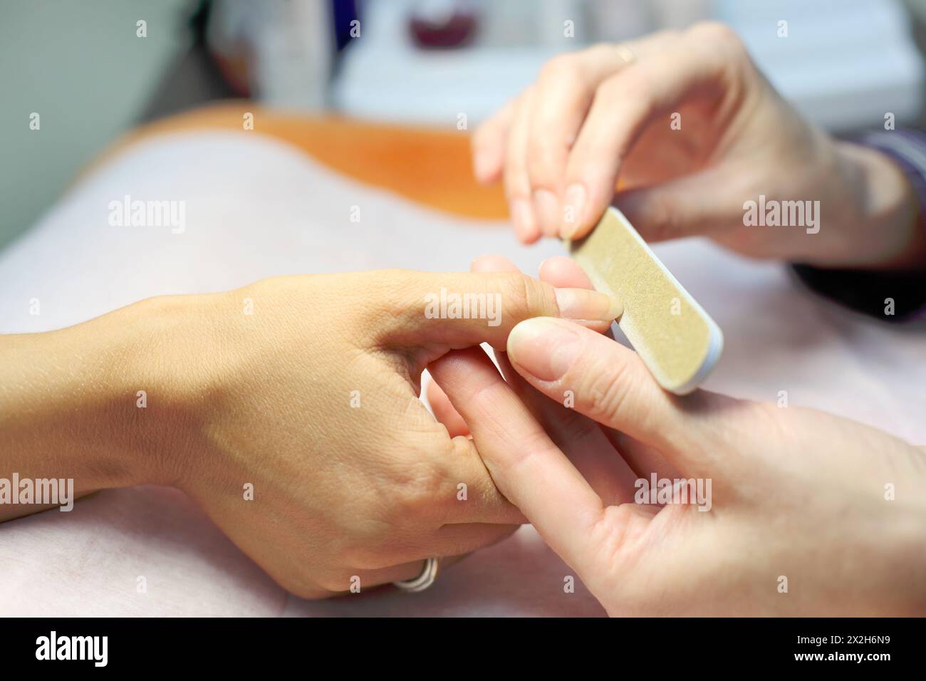 Female hands make manicure by nailfile for woman in beauty salon Stock ...