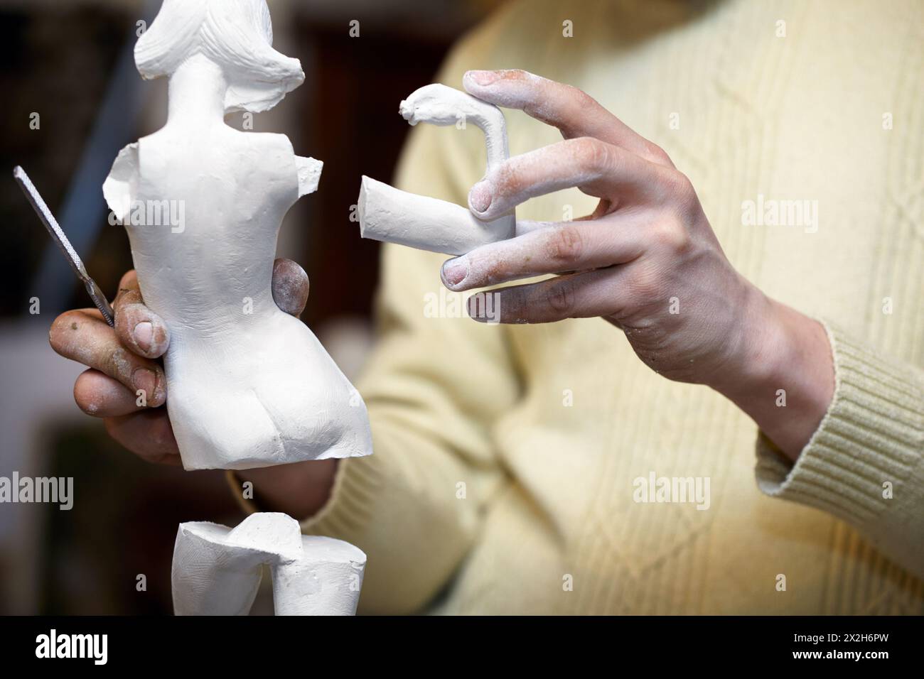 Hands of sculptor hold parts of plaster statuette Stock Photo - Alamy