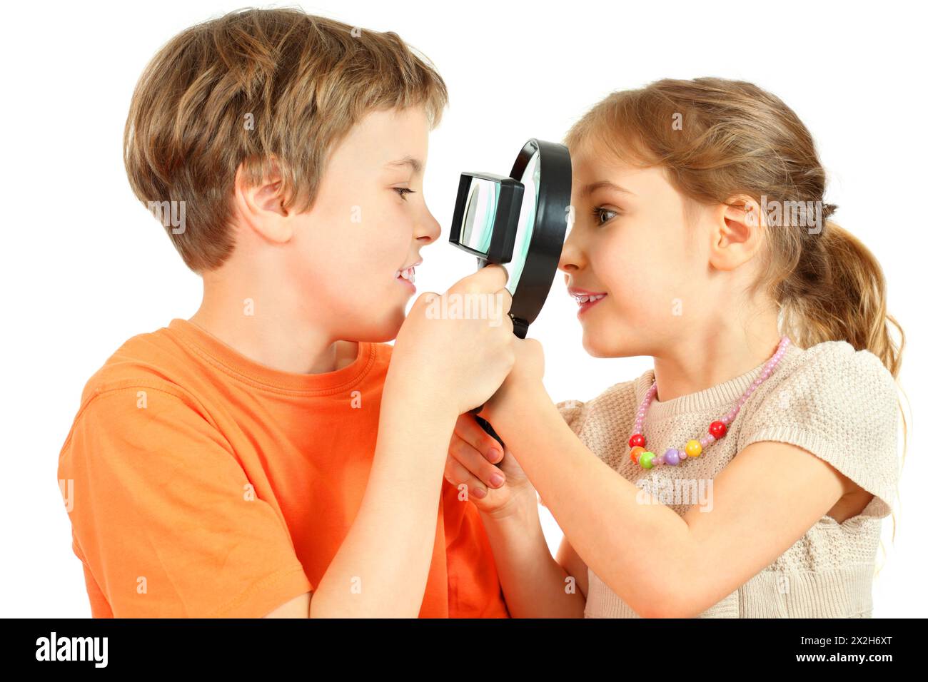 Brother and sister look at each other through magnifying glasses ...