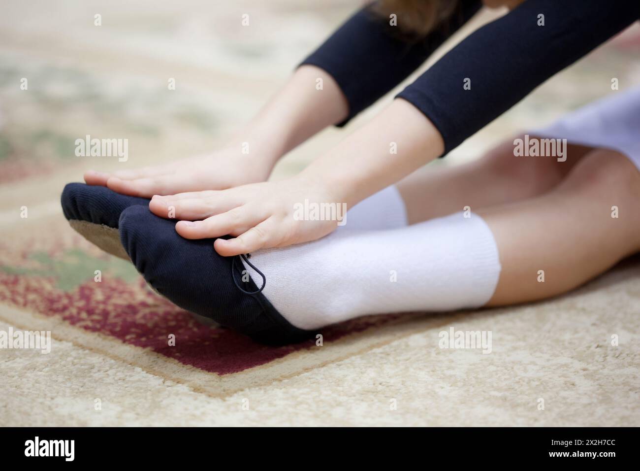 Exercise on extension. Hands reach for foot leg. Gymnastic footwear ...