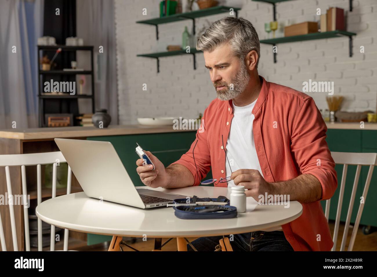 Diabetic patient man holding glucose meter using laptop having online ...