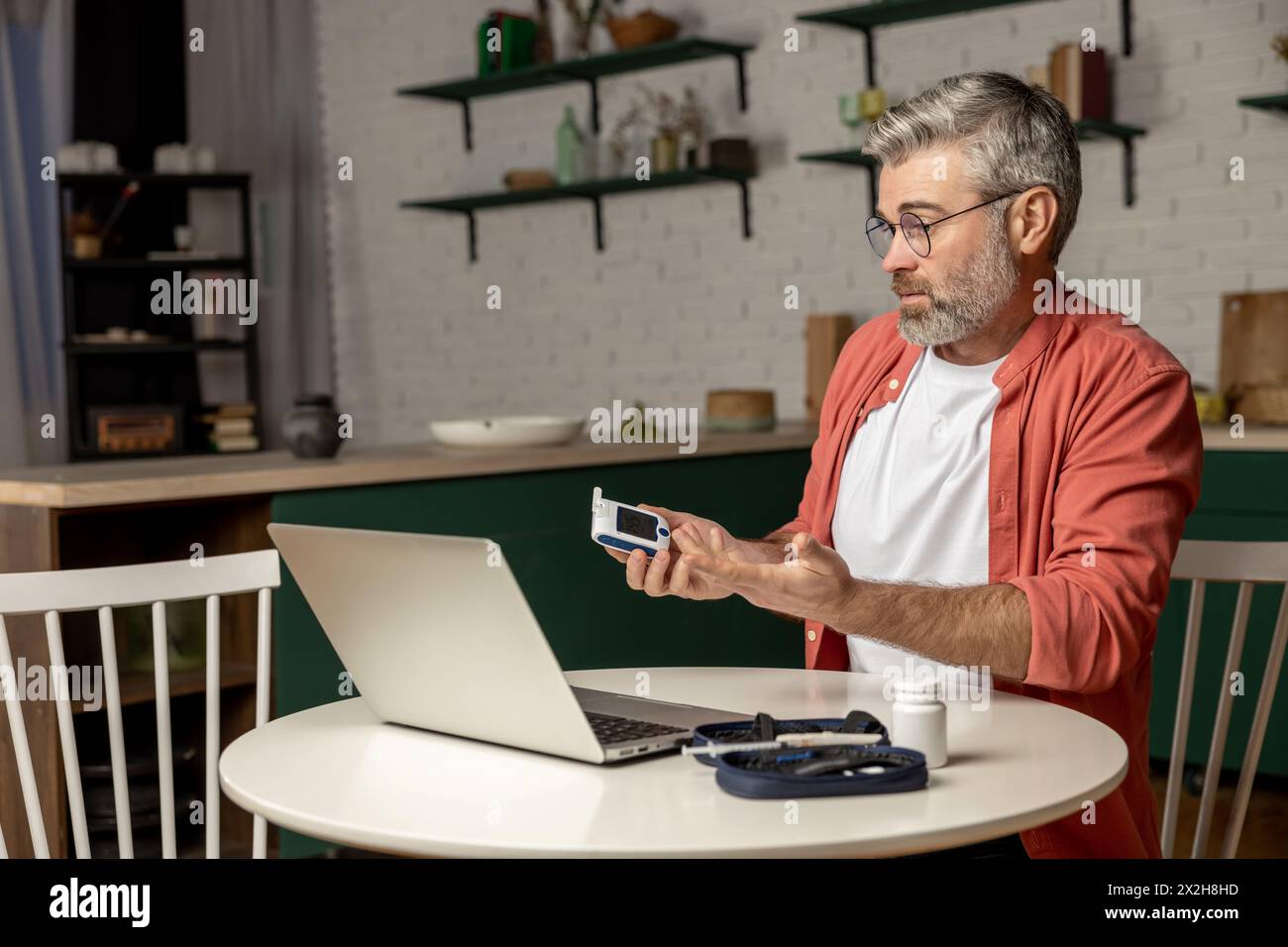 Diabetic patient man holding glucose meter using laptop having online ...
