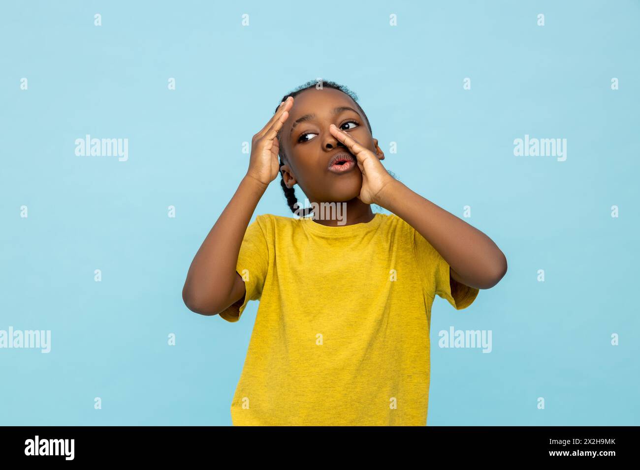 Funny dark- skinned little boy screaming something with hand near mouth ...