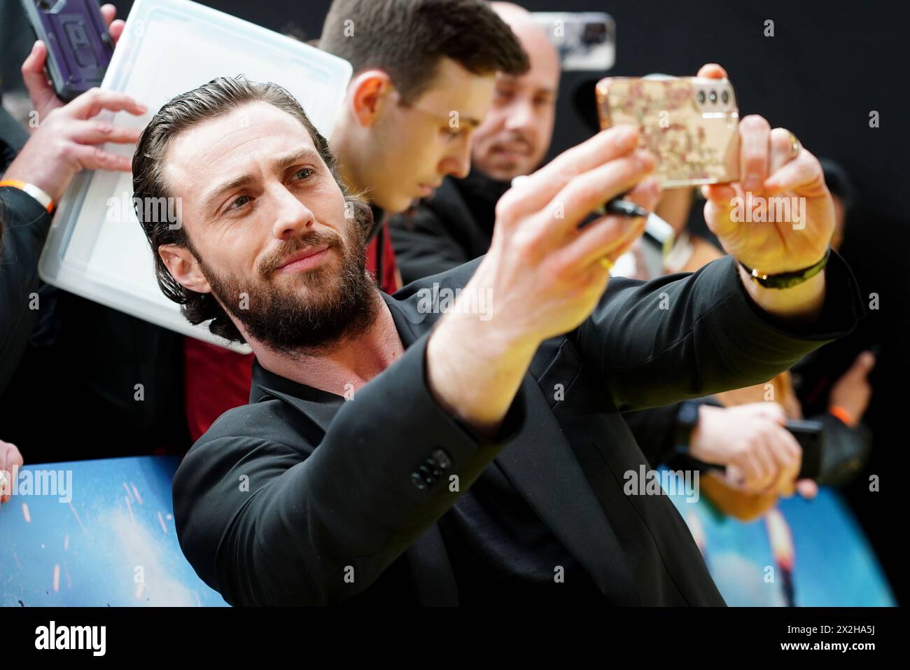 Aaron Taylor-Johnson takes a photo with a fan while attending a special ...