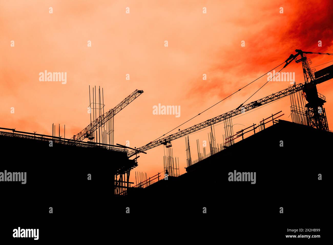 Residential building development and construction, back lit cranes and ...