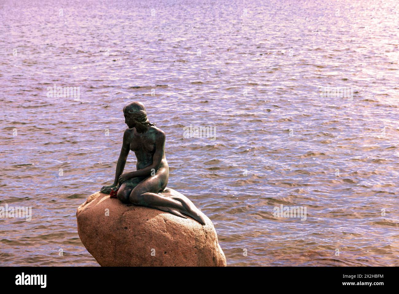 Symbol of Denmark the little mermaid sitting on a stone in Copenhagen ...