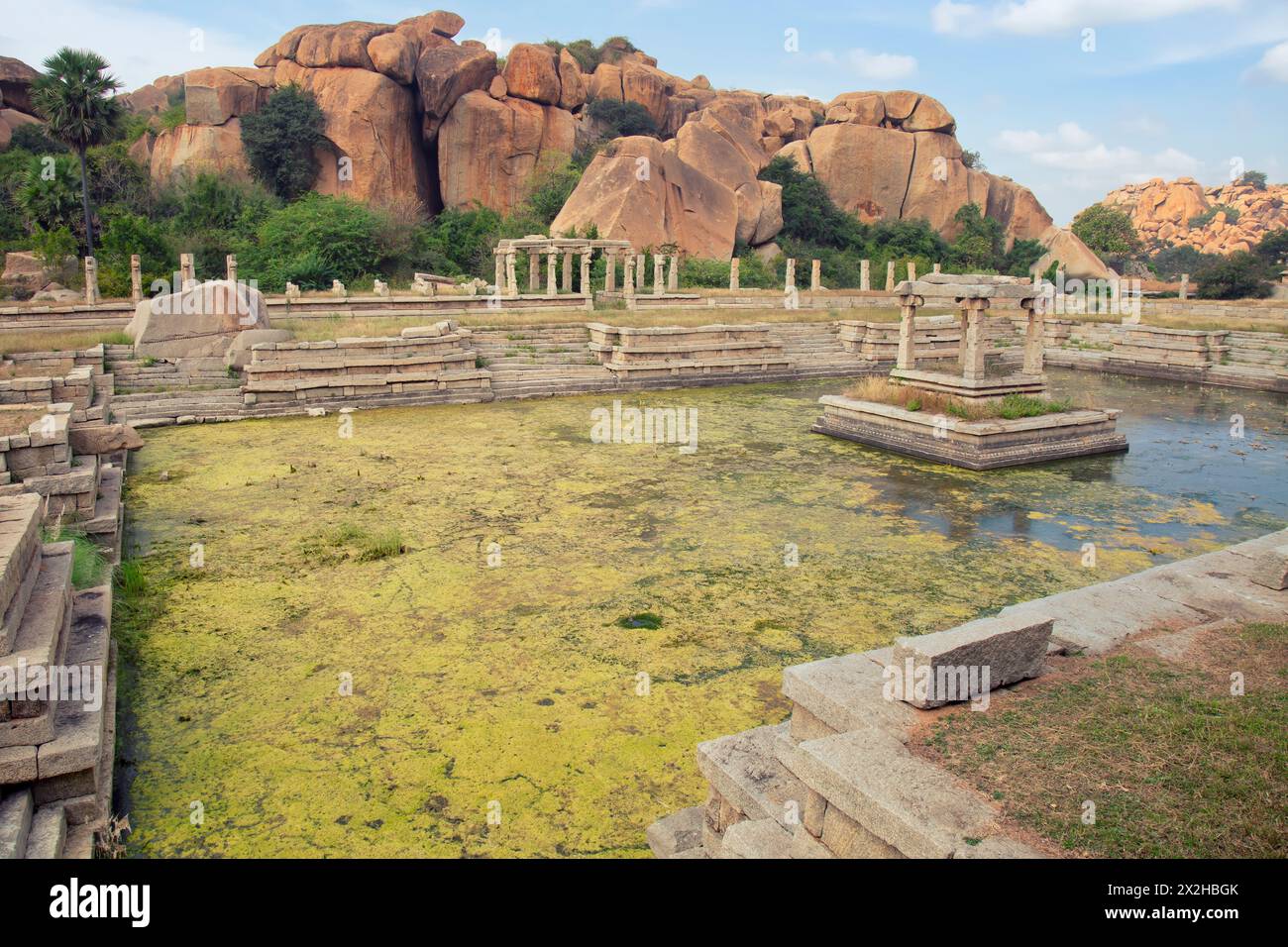 An ancient stone water reservoir known as Pushkarani is surrounded by ...