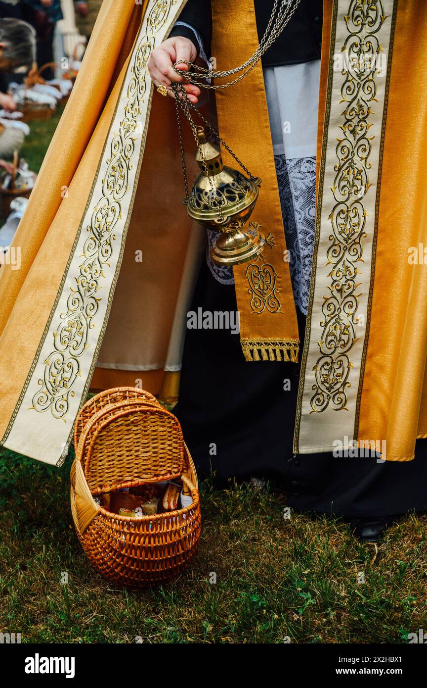 A priest consecrates a traditional Hungarian Easter basket with incense ...