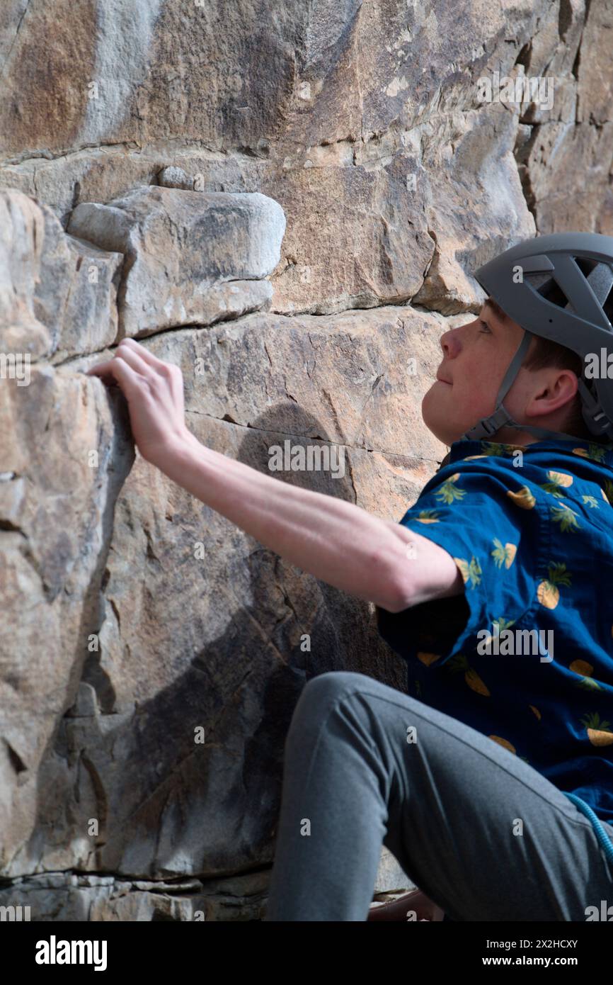 Male climber pulling up on rock face Stock Photo - Alamy