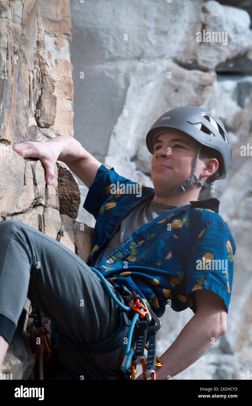 Male climber on side of rock looking at climbing route Stock Photo - Alamy