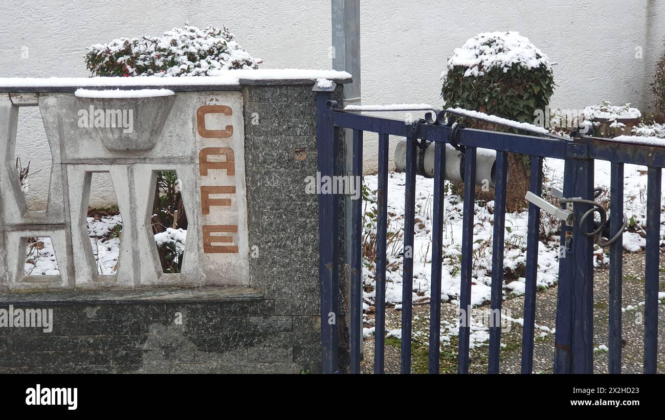 Old closed cafe building and blue metal gate with closed lock and chain ...