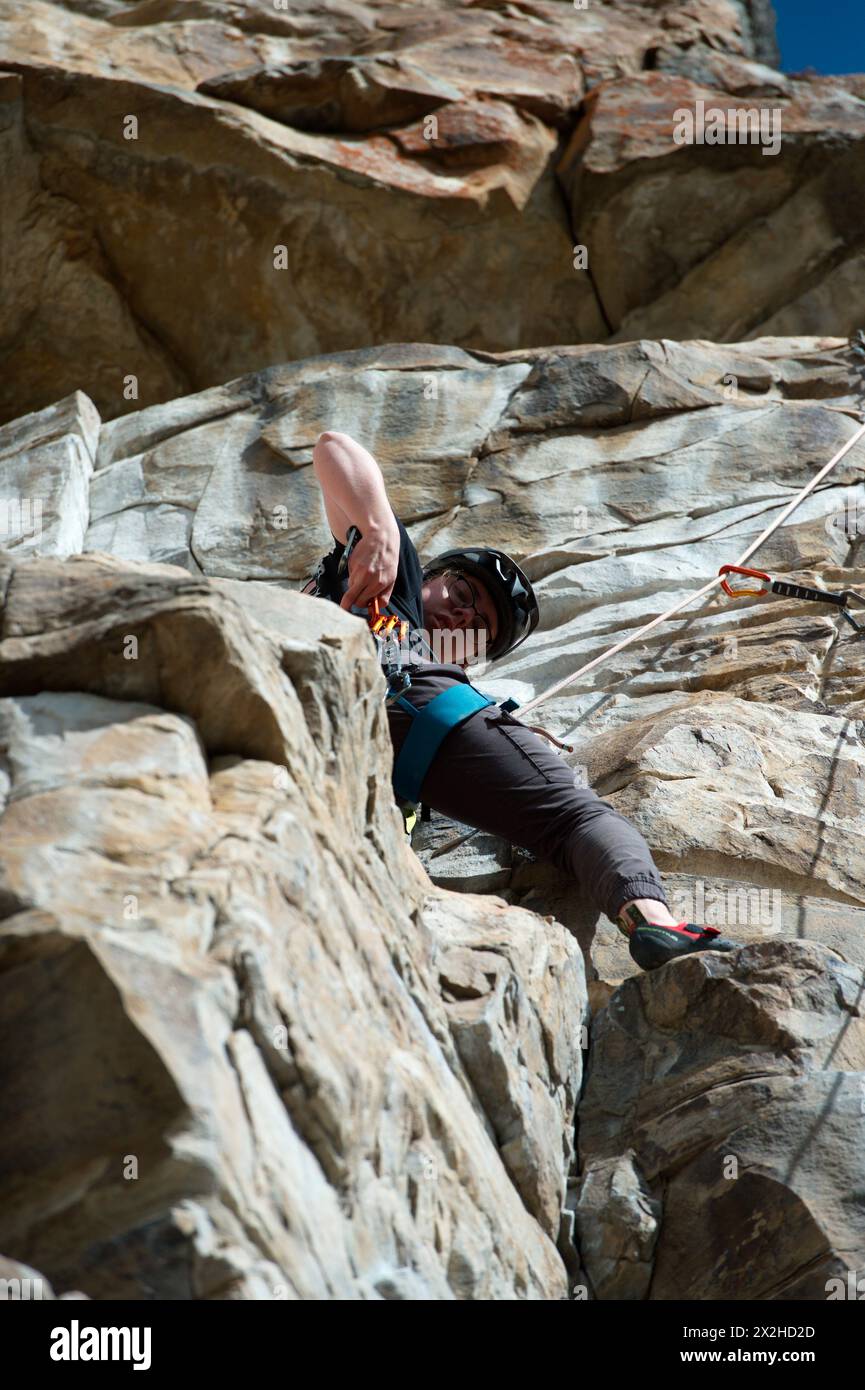 Male climber stopped on ledge while reaching for quick draw Stock Photo ...