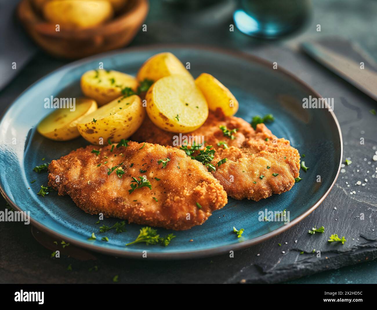 Schnitzel with baked potatoes on modern ceramic plate Stock Photo - Alamy