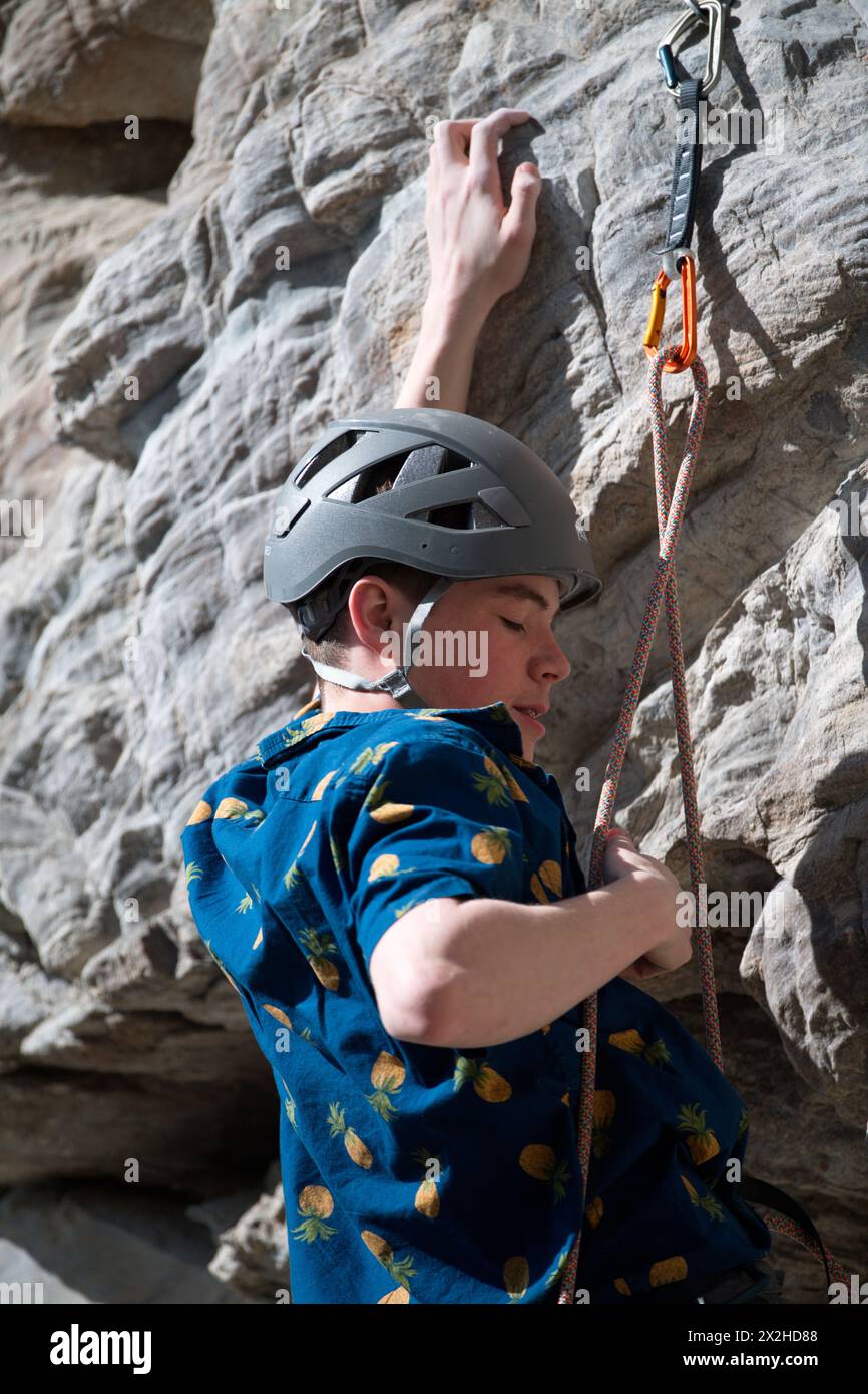 Male climber adjusting rope through quick draw Stock Photo - Alamy