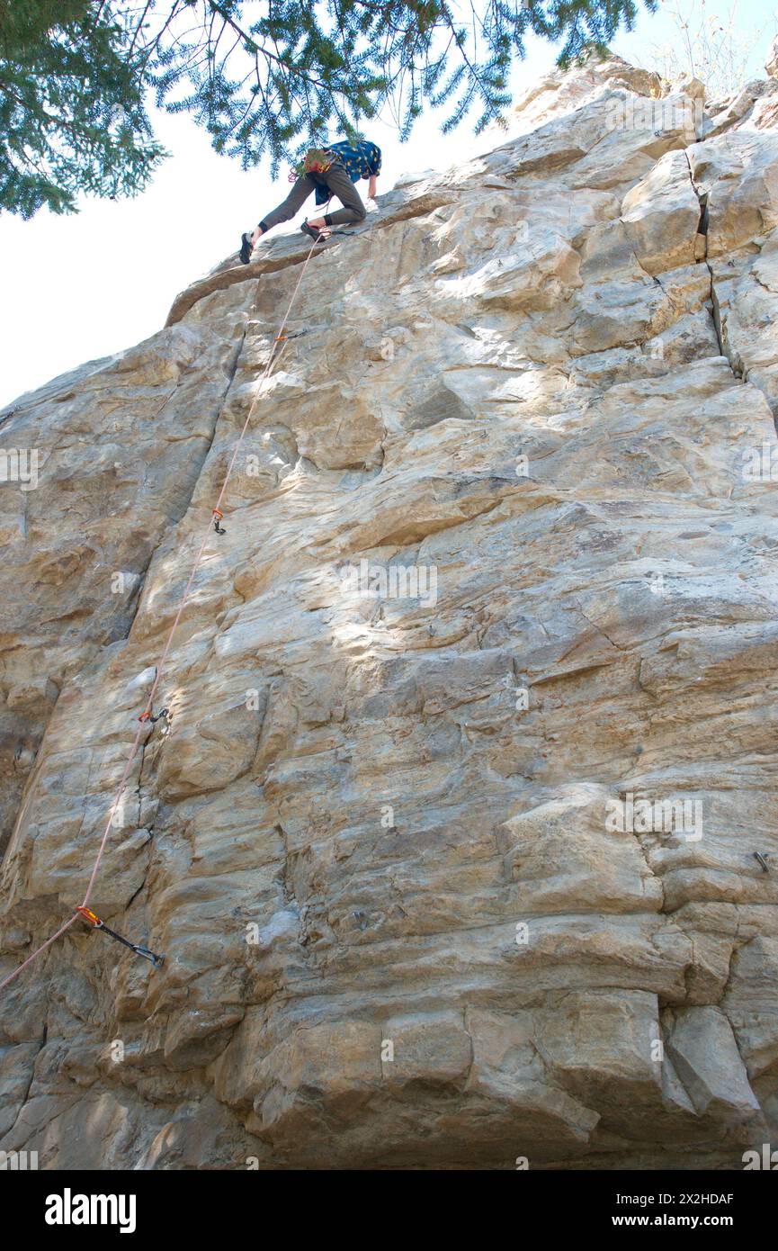 Back of male climber at top of climb showing rope path and sky Stock ...