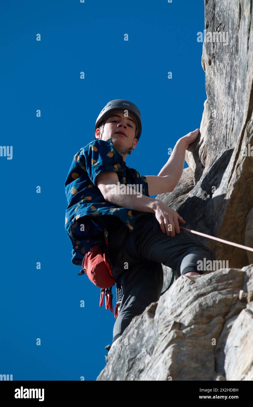 Male climber at top of rock face looking down at camera Stock Photo - Alamy